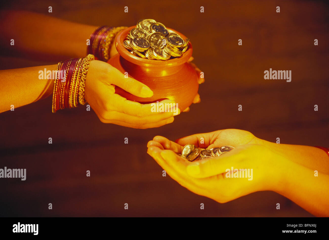 Hand holding coins pot giving to other hand Stock Photo - Alamy