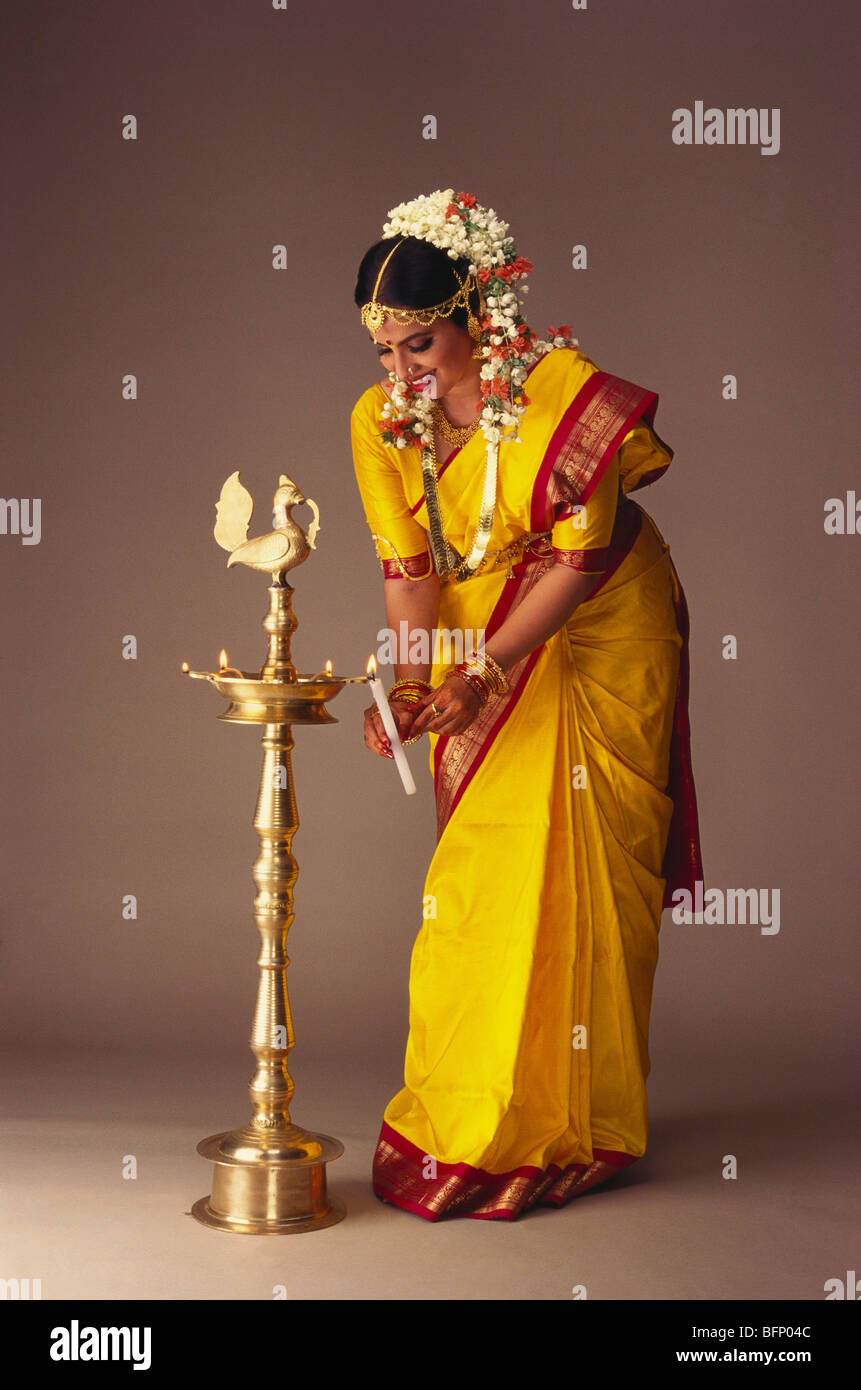Indian woman lighting oil lamp hi-res stock photography and images - Alamy