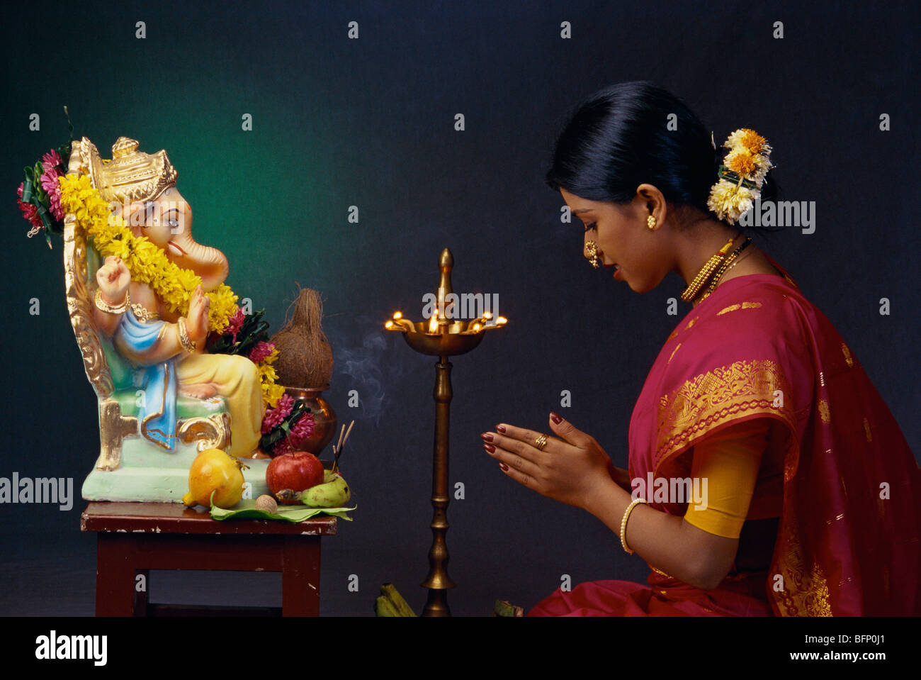 Ganesh Festival ; woman praying to Lord Ganesha idol ; India ; Asia ...