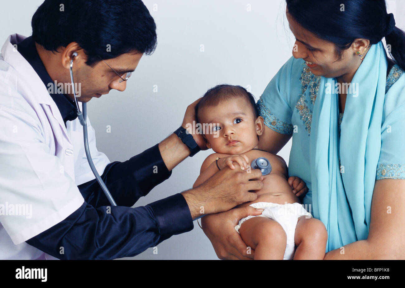 Doctor examine checking baby with stethoscope in lap of mother MR#364 ...