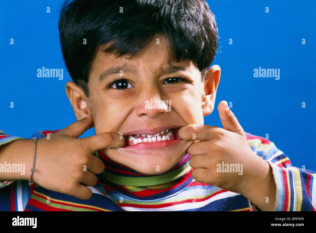Indian boy child opening and stretching mouth to show teeth ; india ...