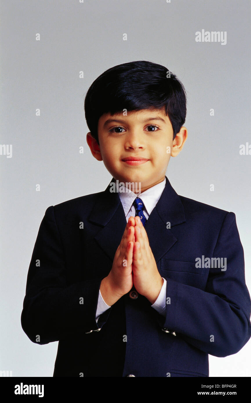 Boy fancy dress as Christian in welcome pose hello greetings namaste ...