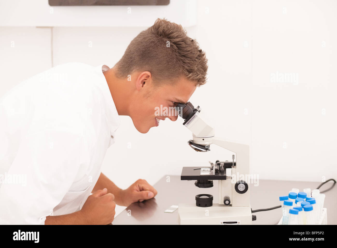 Laboraratory woirk: young smiling researcher looks in microscope Stock ...