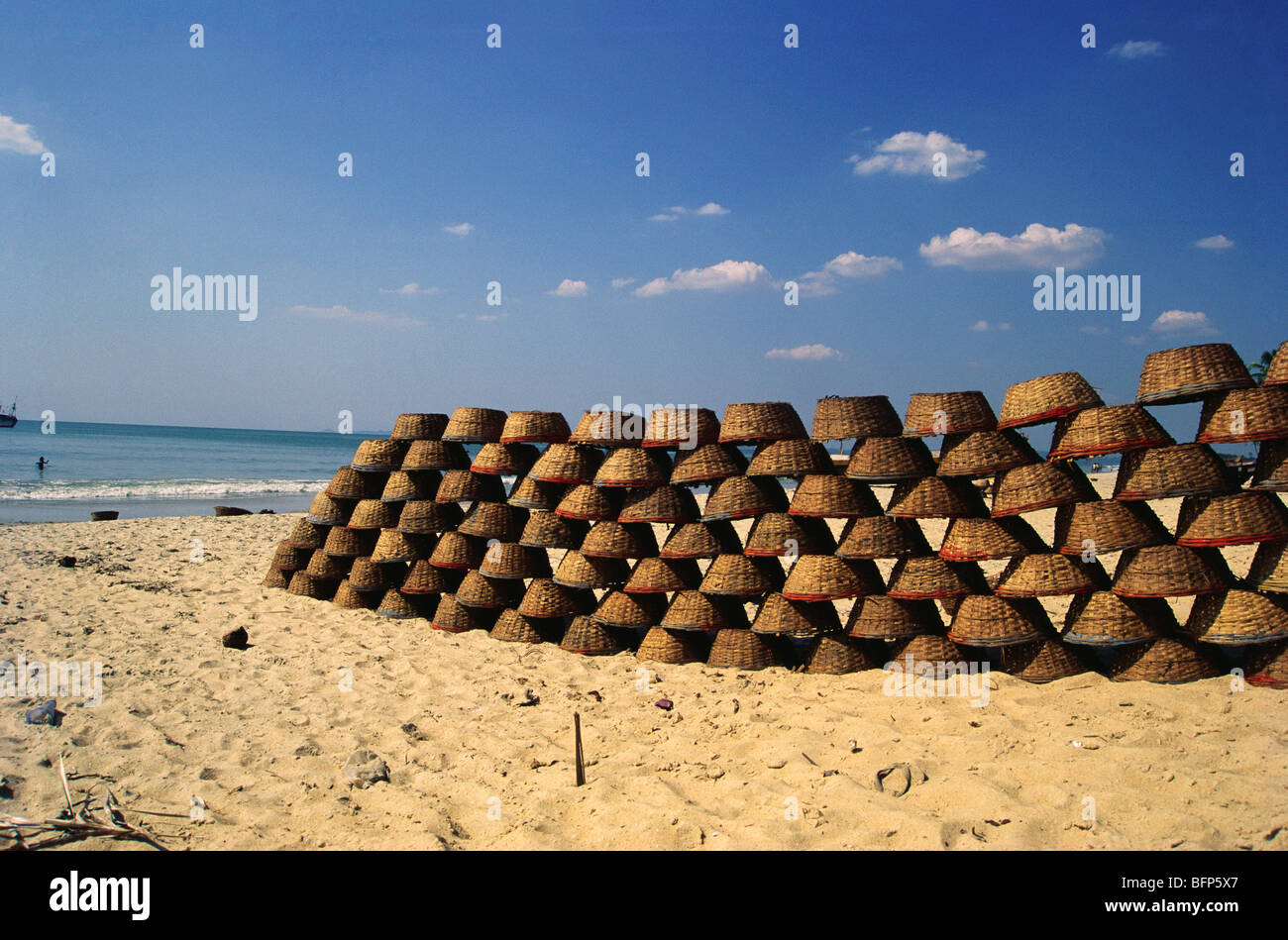 Row of fishermen round cane baskets ; Colva beach ; Goa ; India ; asia ...