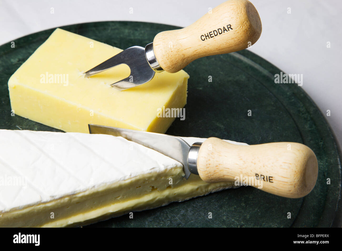 Somerset brie and mature cheddar cheese on a cheese coard with a brie ...