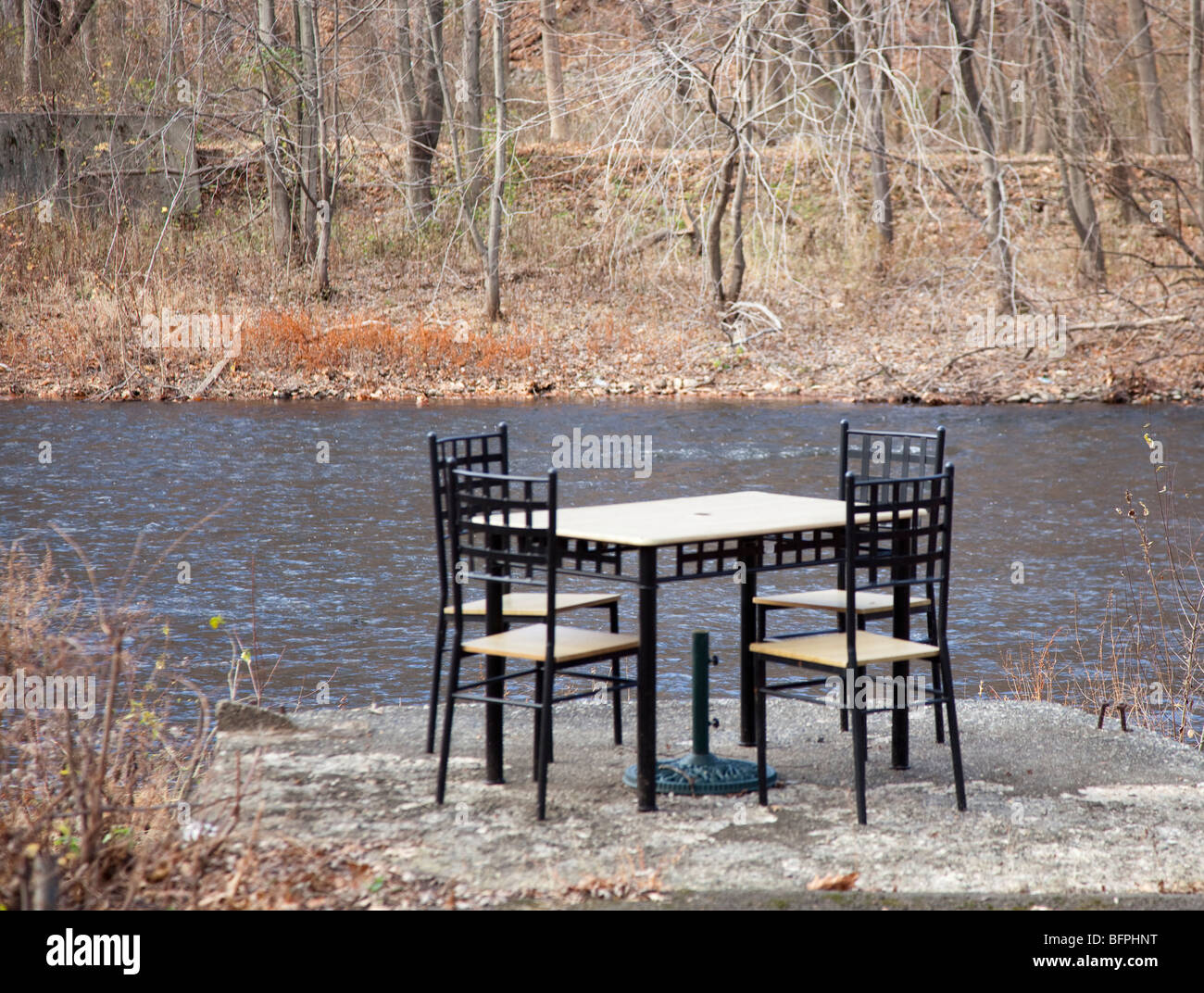 Table and chairs by the side of a river Stock Photo - Alamy