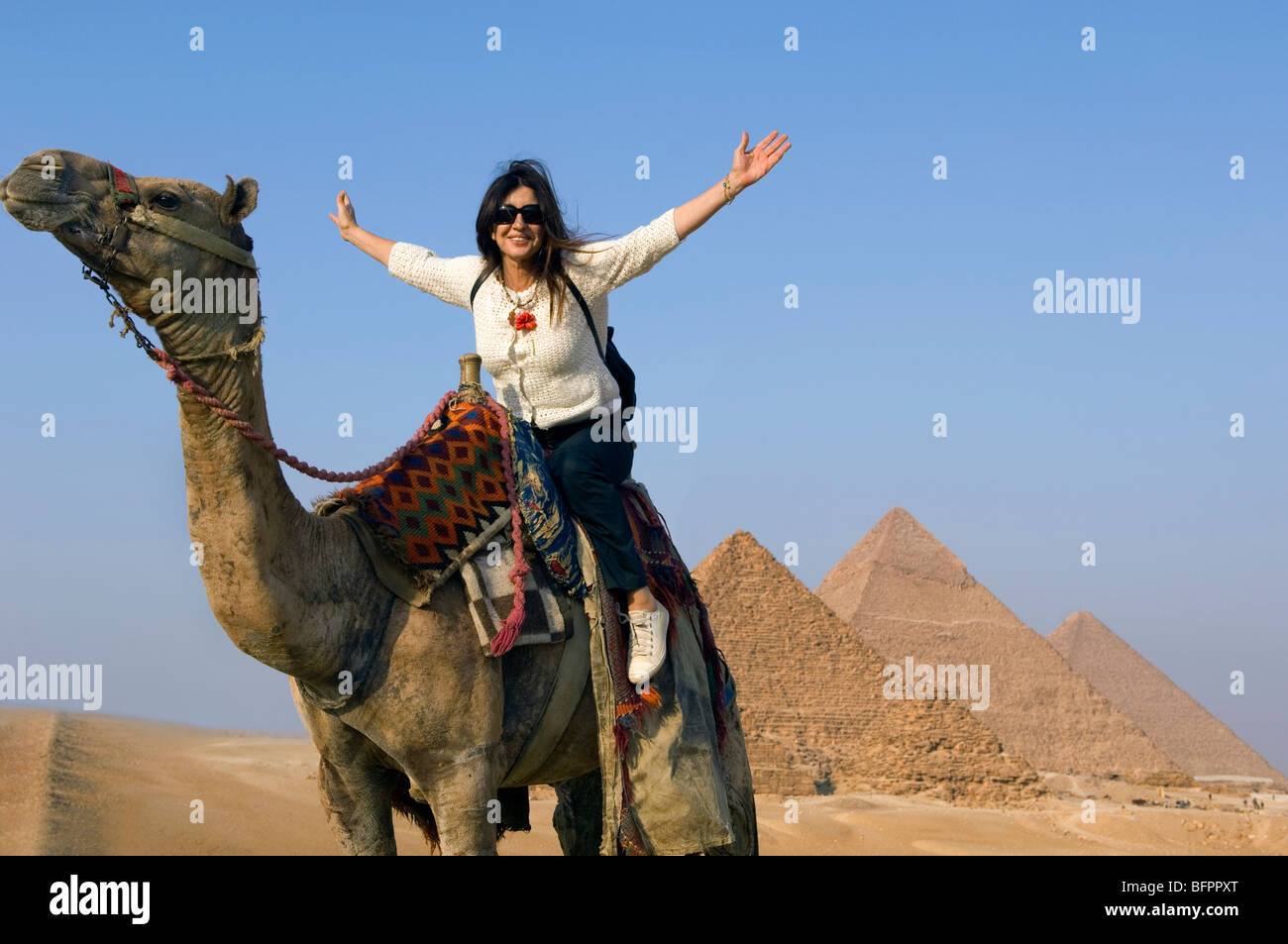 Woman on camel back visiting the Pyramids Stock Photo - Alamy
