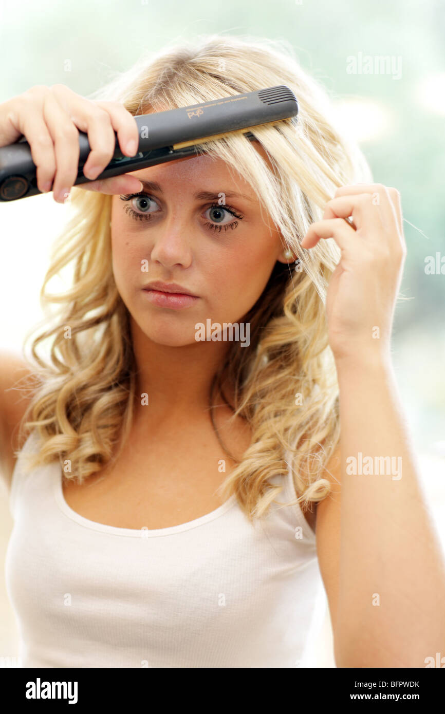 Teenage Girl Using Hair Tongs. Model Released Stock Photo - Alamy