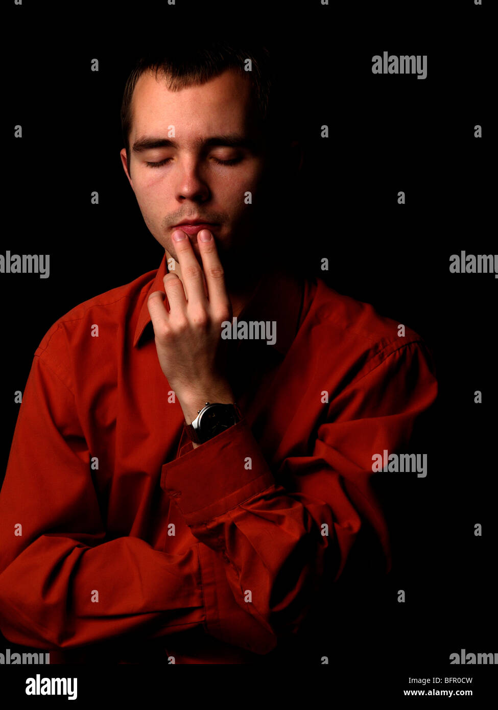 Young man thinking black background isolated portrait Stock Photo - Alamy