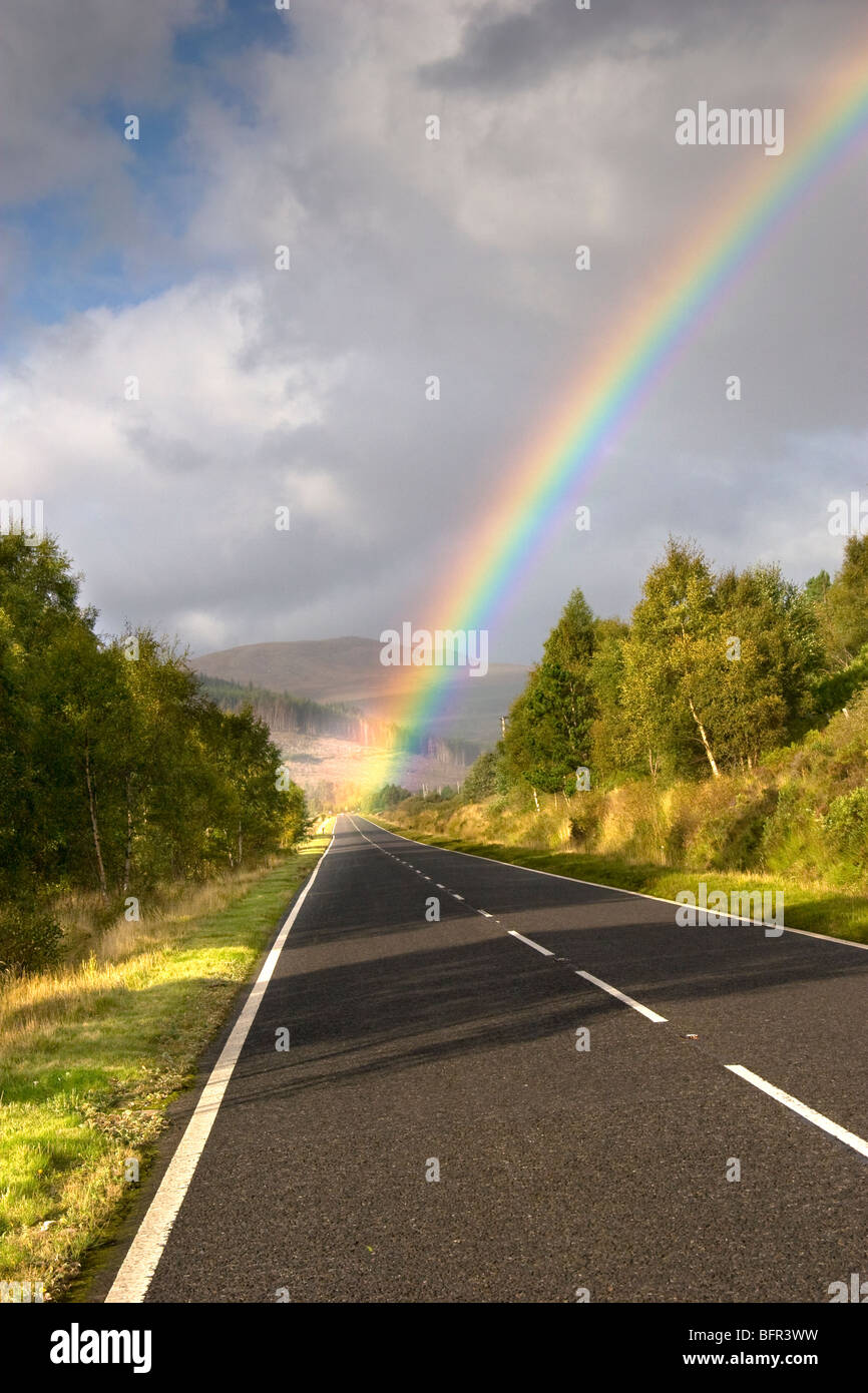 Rainbow at the end of a long straight road Stock Photo - Alamy