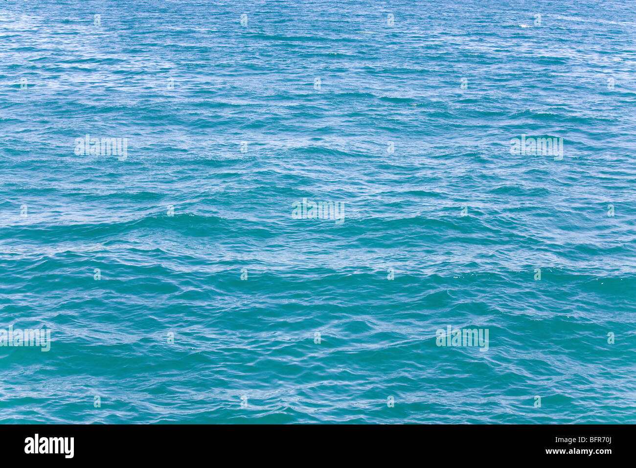 Azure sea water surface with ripple and cloud reflections Stock Photo ...