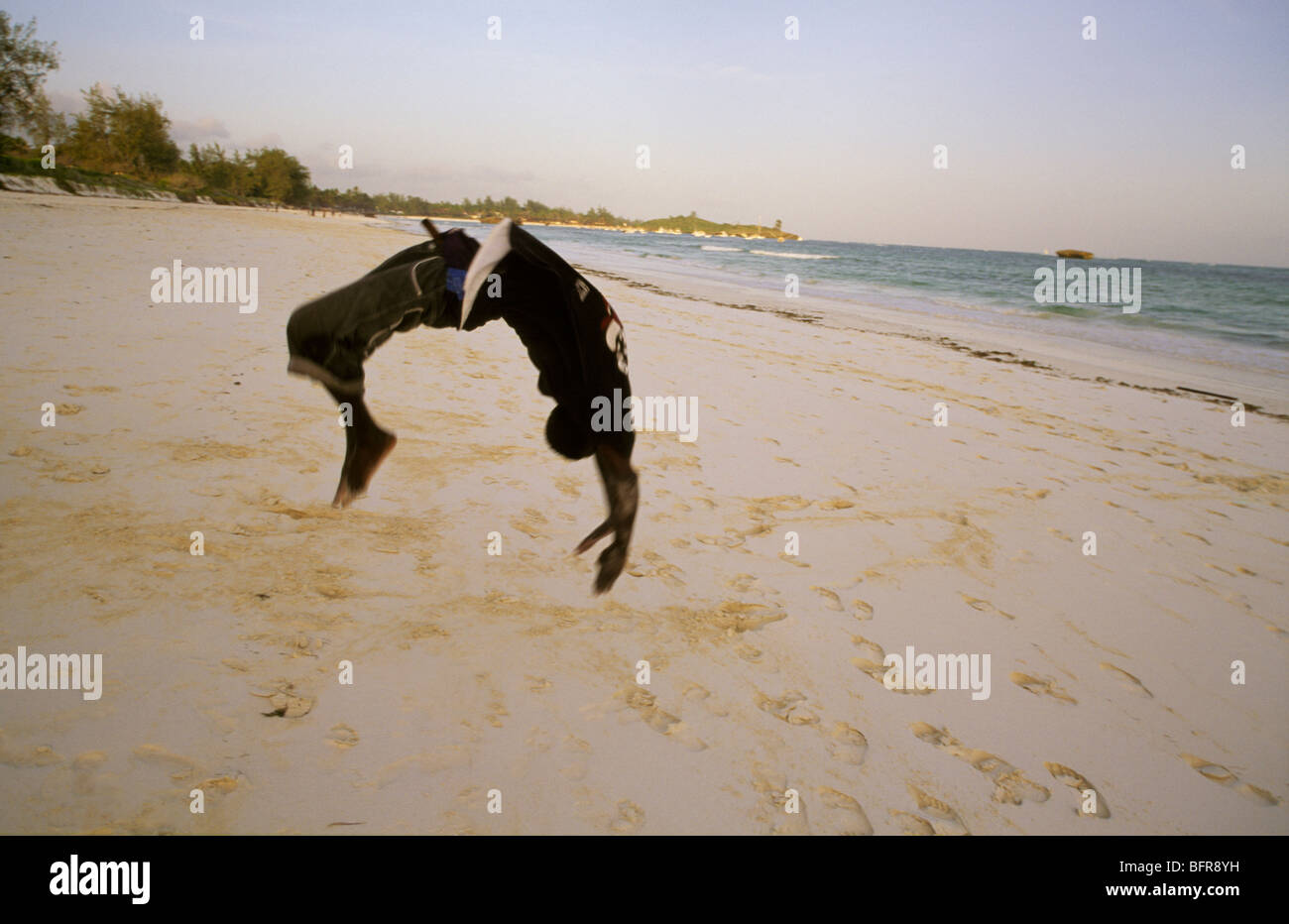 Local boy doing backward somersault on the beach Stock Photo - Alamy