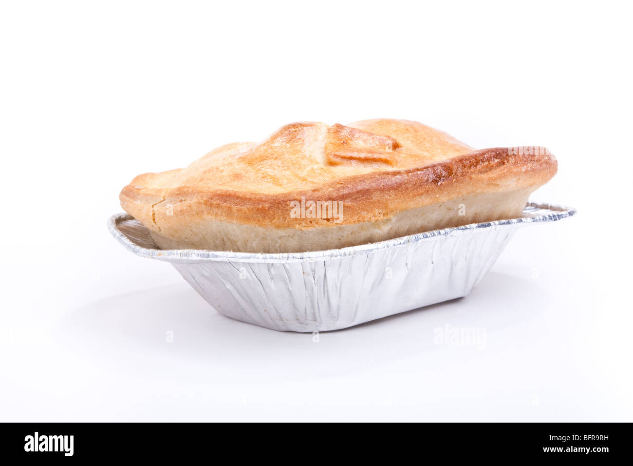Individual short crust pastry steak pie in silver foil tray isolated ...