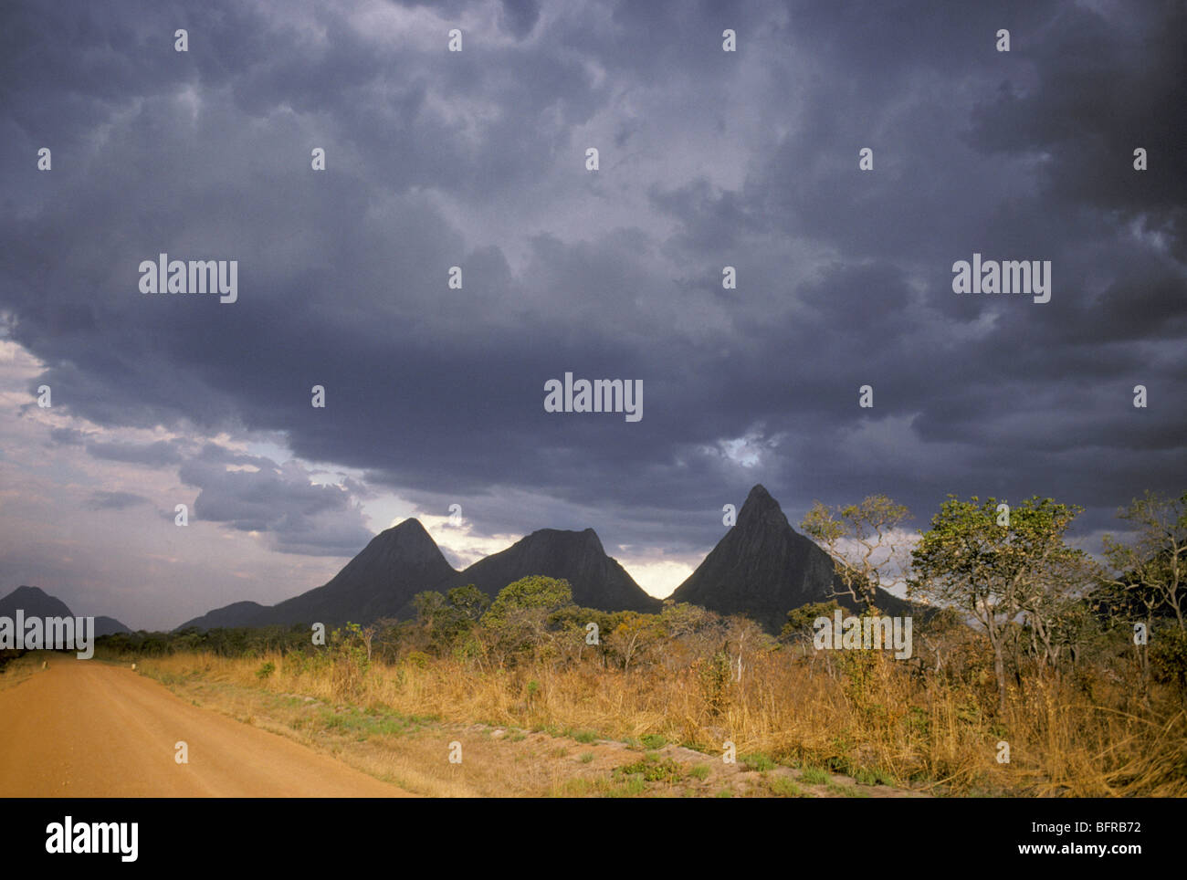 Granite inselberg on the road to Cuamba with ominous grey clouds ...