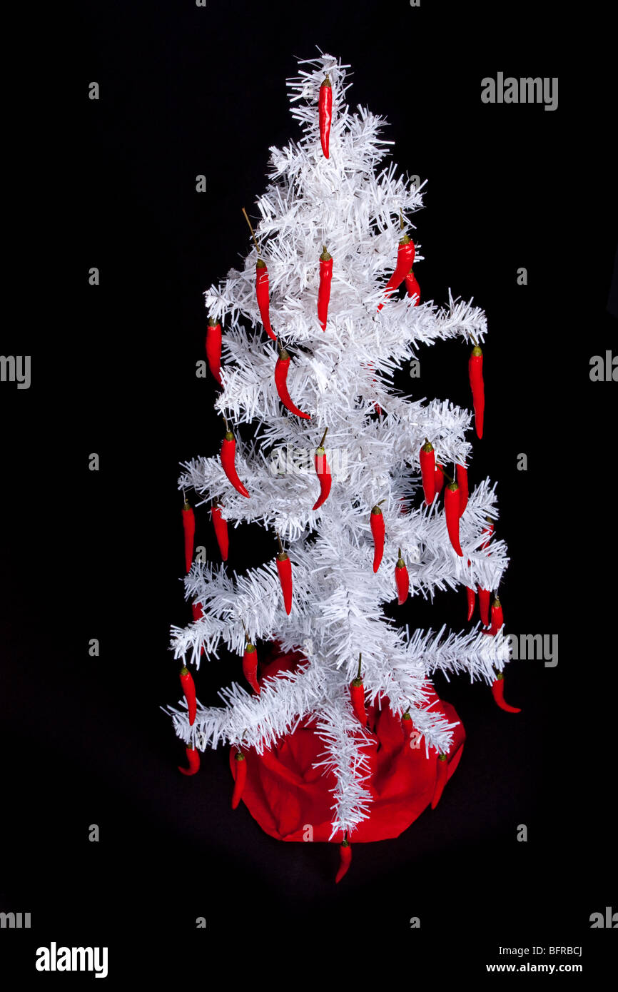 Abstract Artificial white christmas tree with fresh red chilli peppers ...