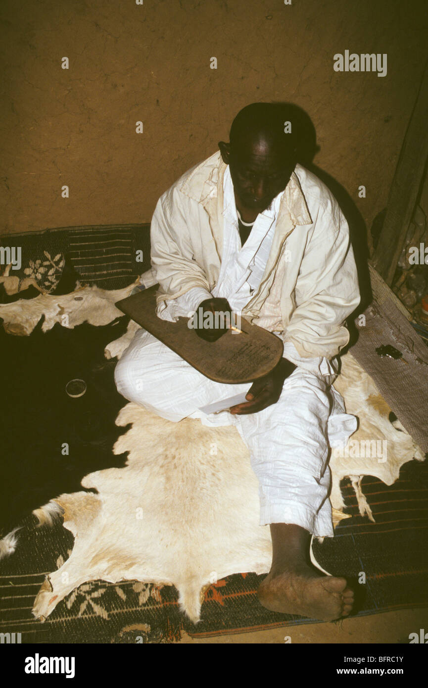 scholar writing notes from the Koran onto a wooden tablet Stock Photo ...