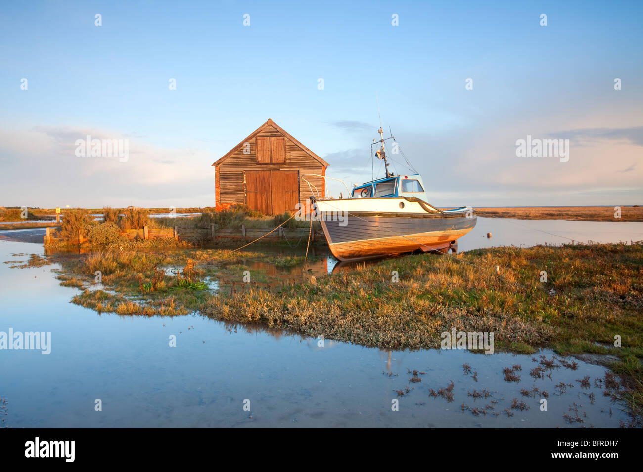The flooded salt marshes and boat house/former coal shed at high tide ...