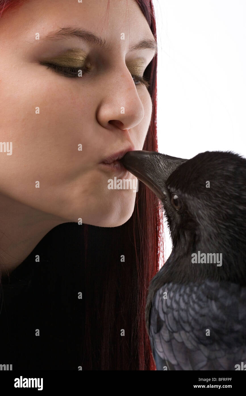 young red-haired woman with big black raven on white background Stock ...