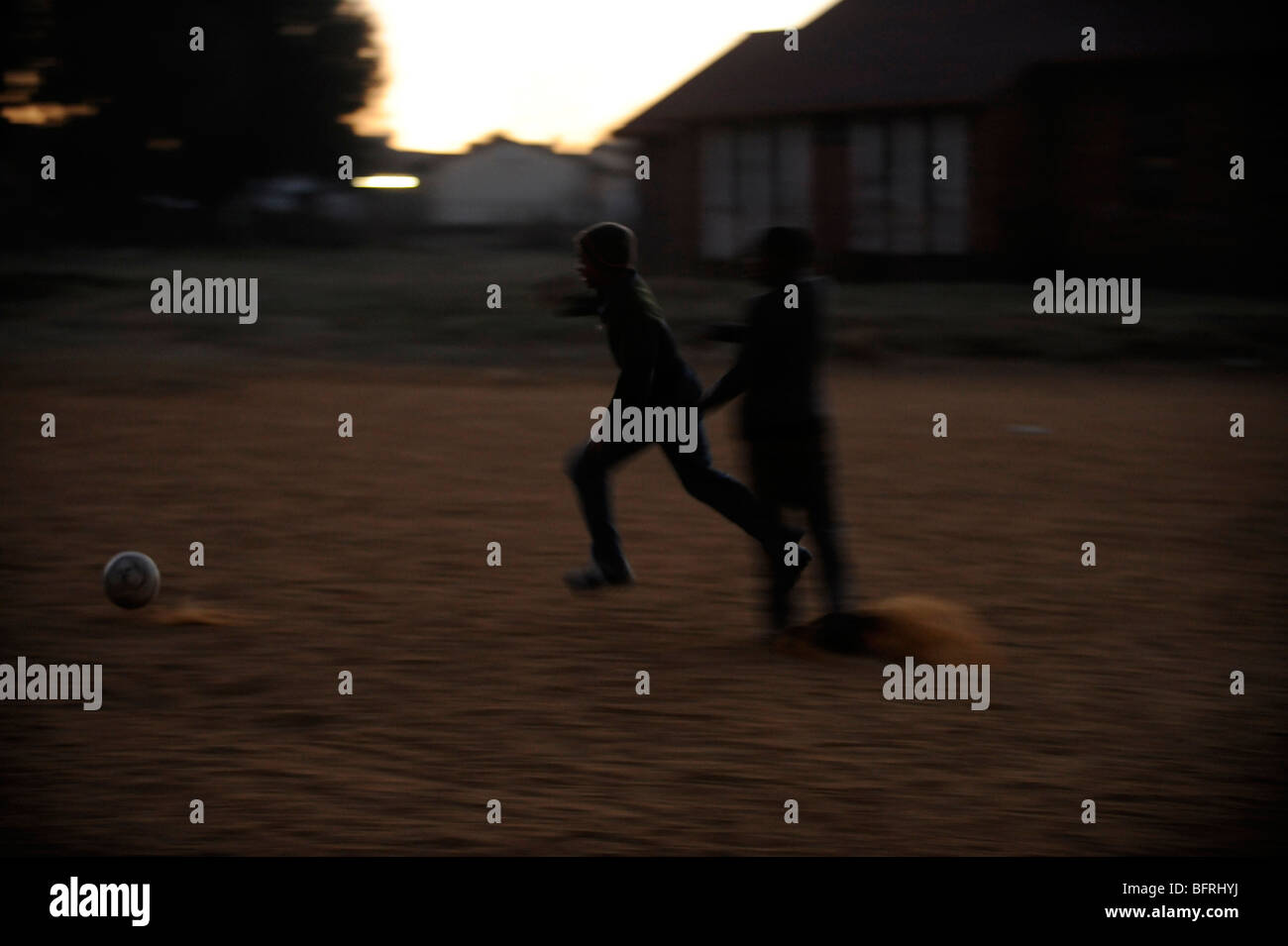 South African boy playing football on a sandy pitch Stock Photo - Alamy