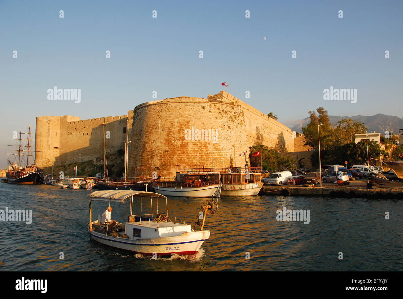 NORTH CYPRUS. A small fishing boat passes Kyrenia castle on its way ...