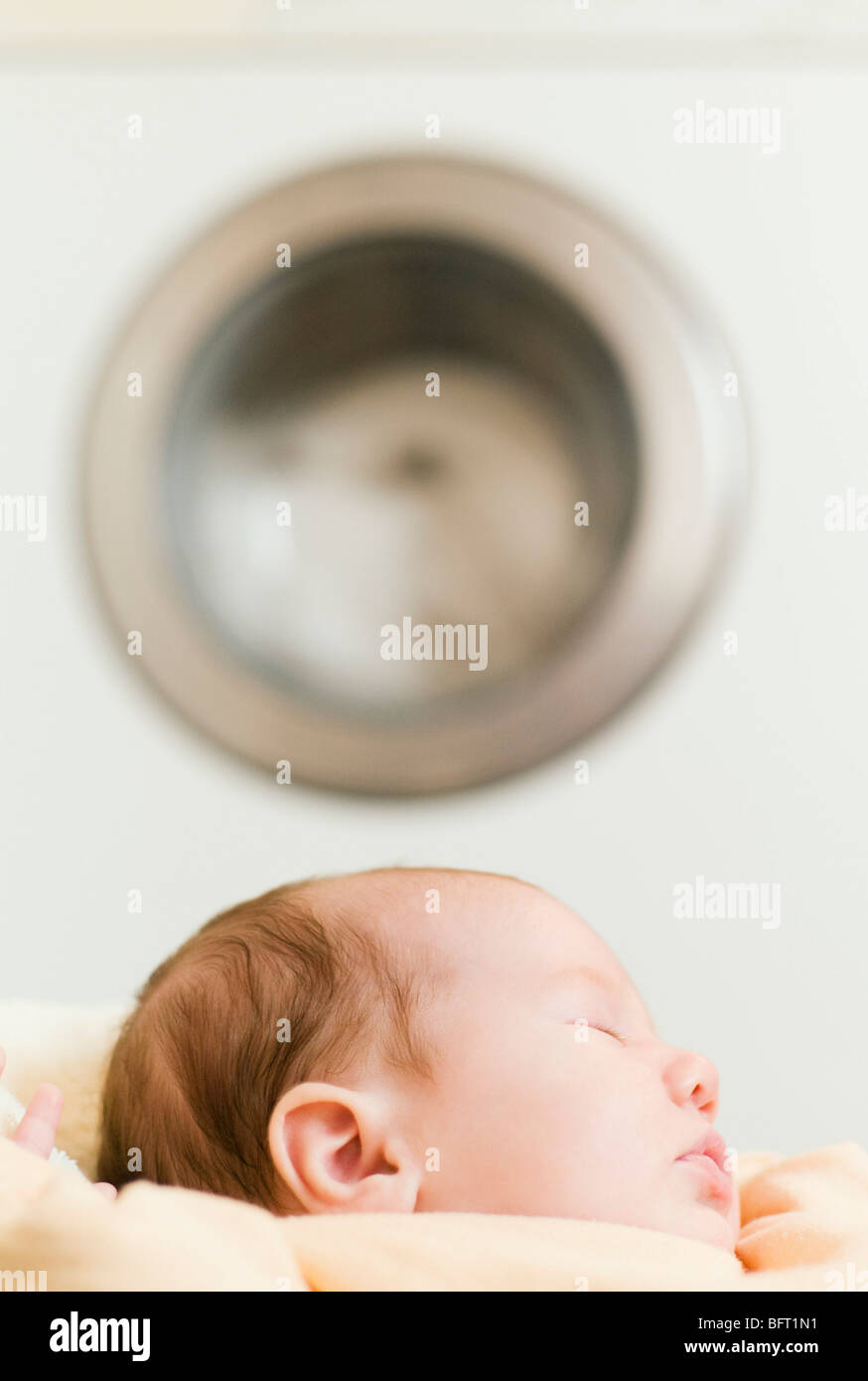 Baby Sleeping near Washing Machine Stock Photo - Alamy