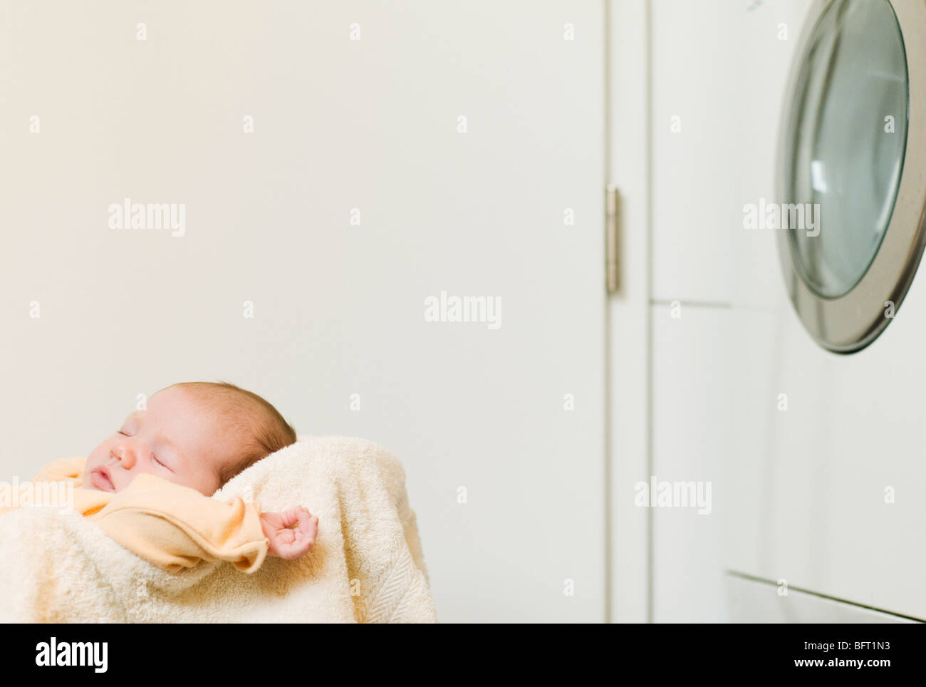 Baby Sleeping near Washing Machine Stock Photo - Alamy