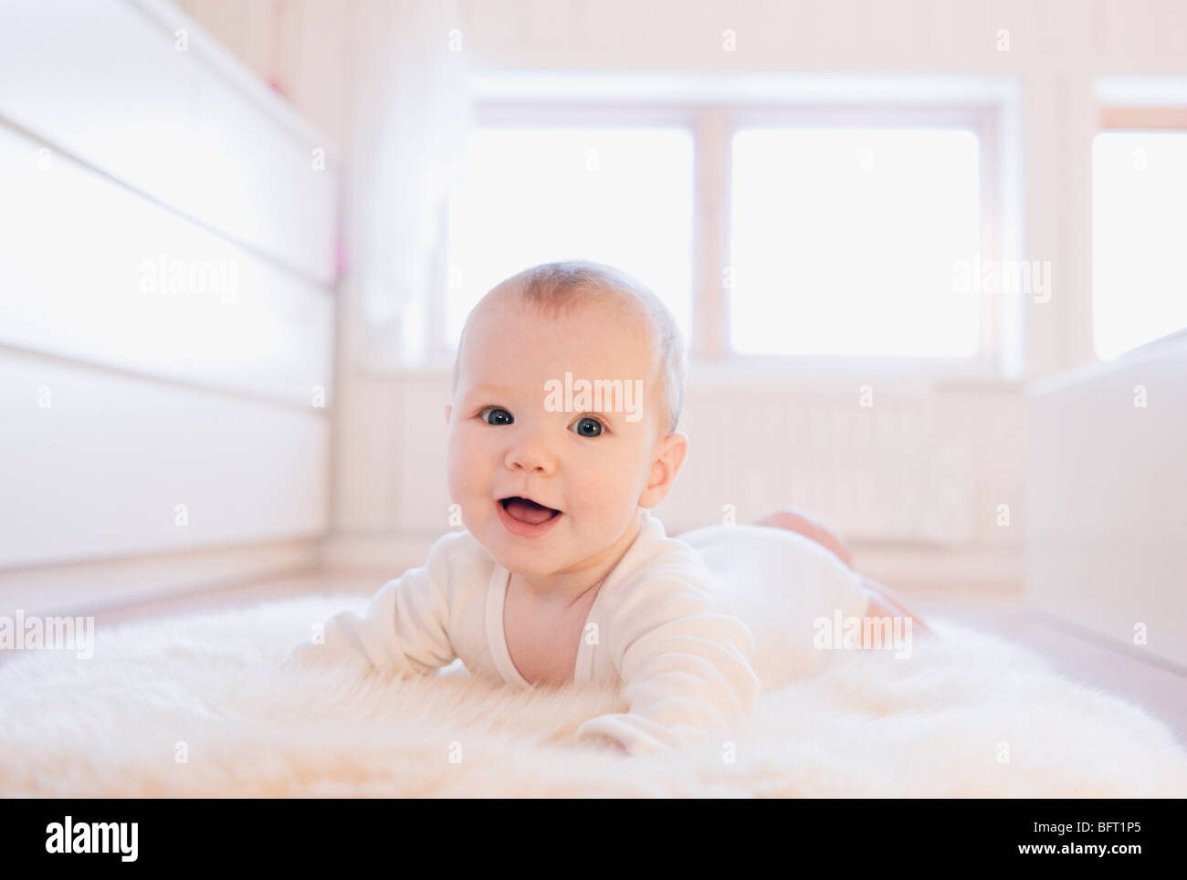 Baby Lying on Rug Stock Photo - Alamy