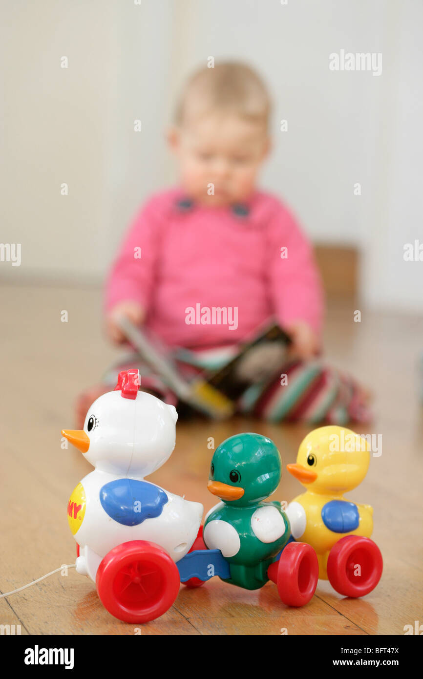 Close-up of Toy Ducks, Baby Girl in the Background Reading a Book Stock ...