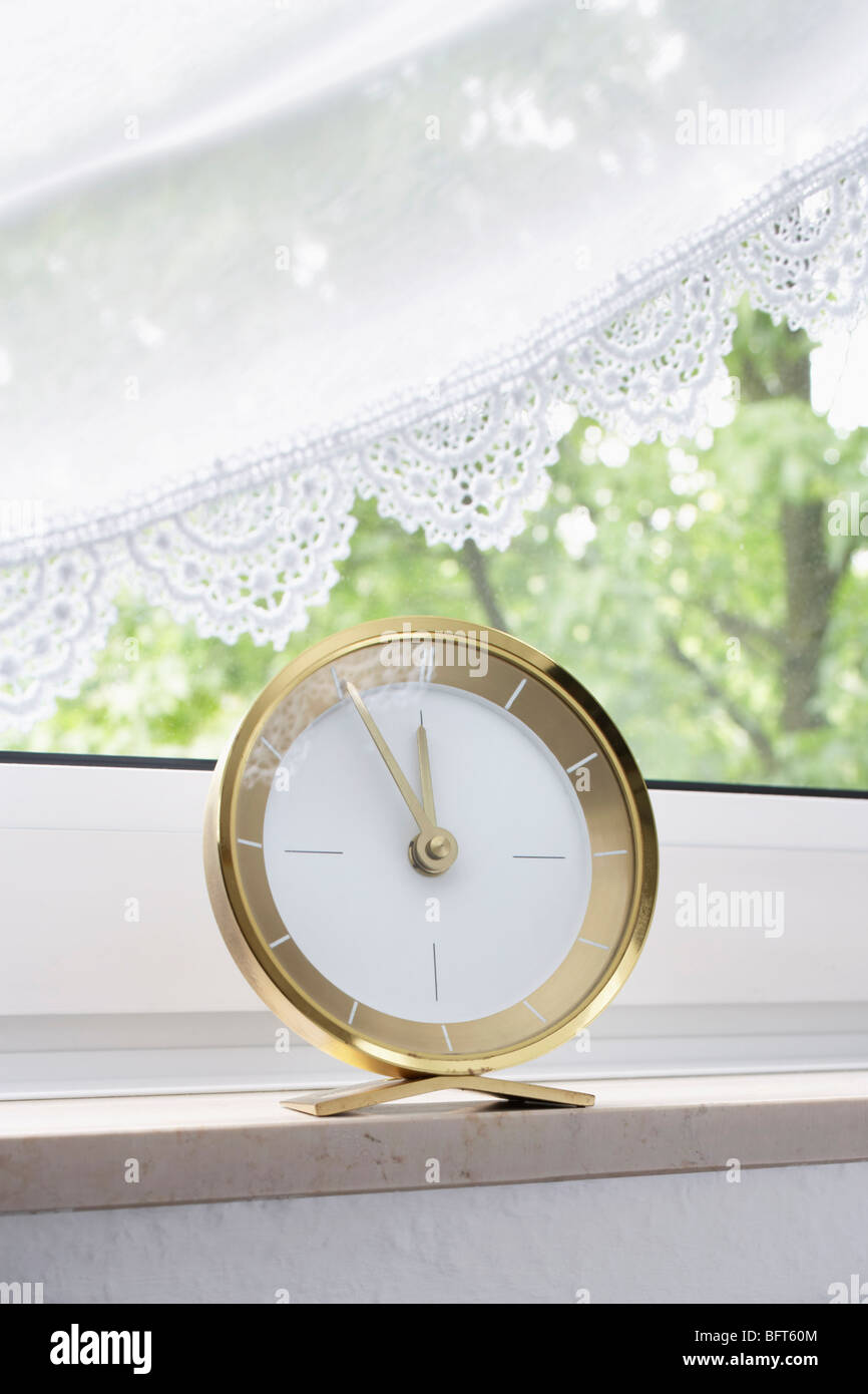 Clock on a Window Sill Stock Photo - Alamy