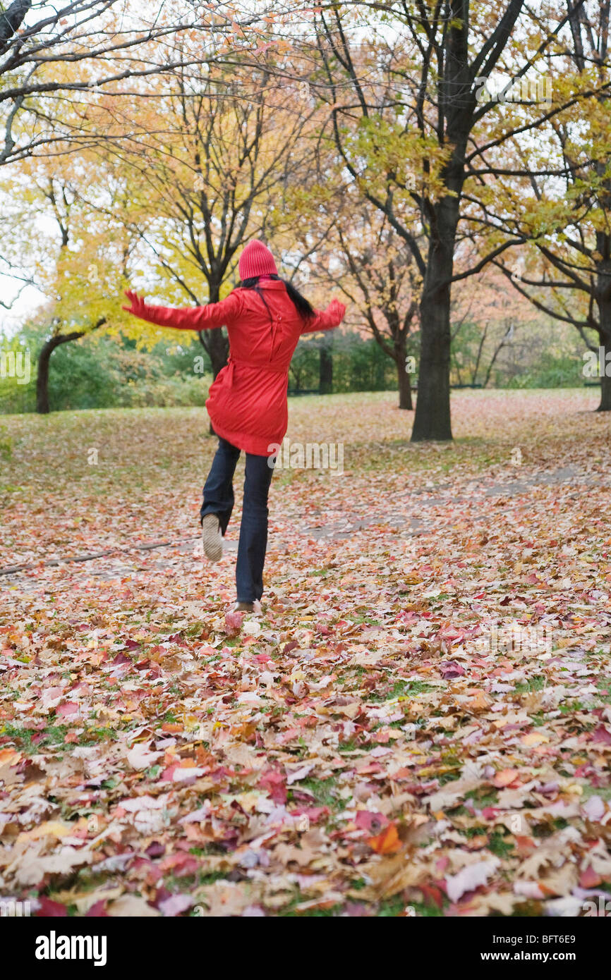 Woman Skipping through Autumn Leaves Stock Photo - Alamy