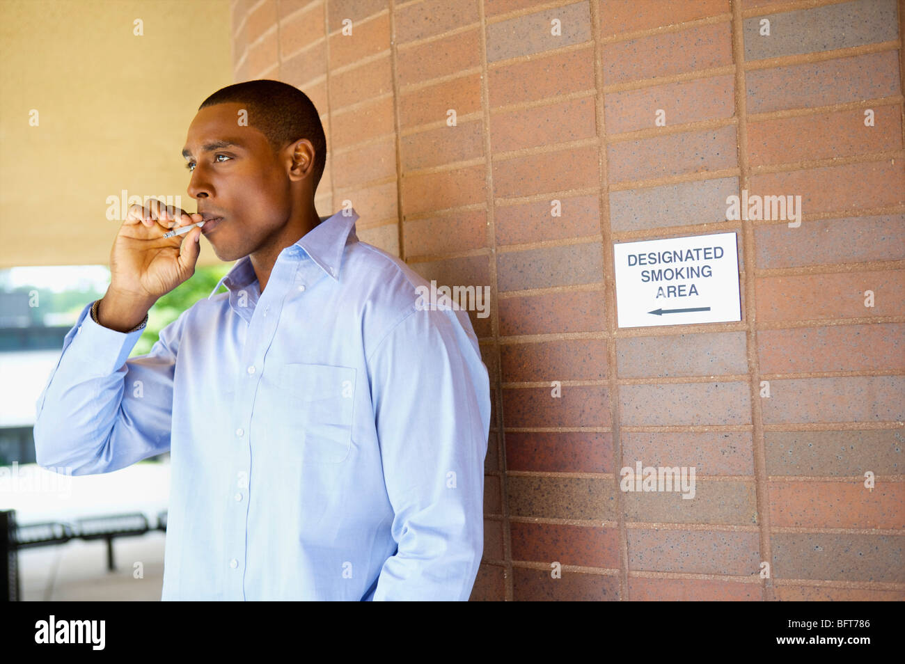Man Smoking a Cigarette in Designated Area Stock Photo - Alamy