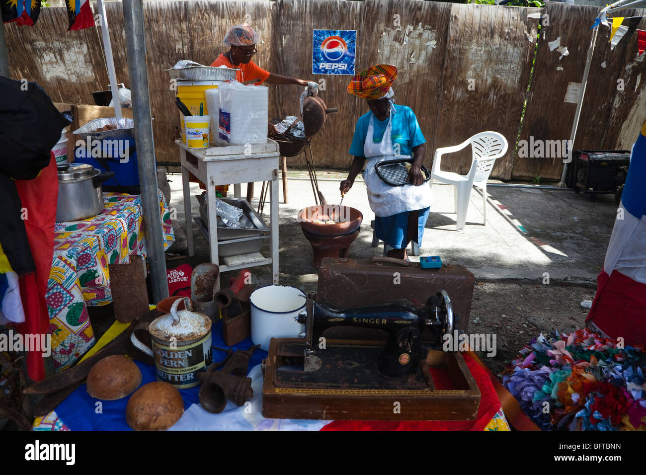 Two women cooking and barbecuing food at a jumble stall during ...