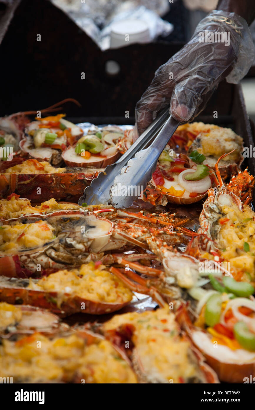 Cooked lobster prepared in its shells and with garnish, being barbecued ...