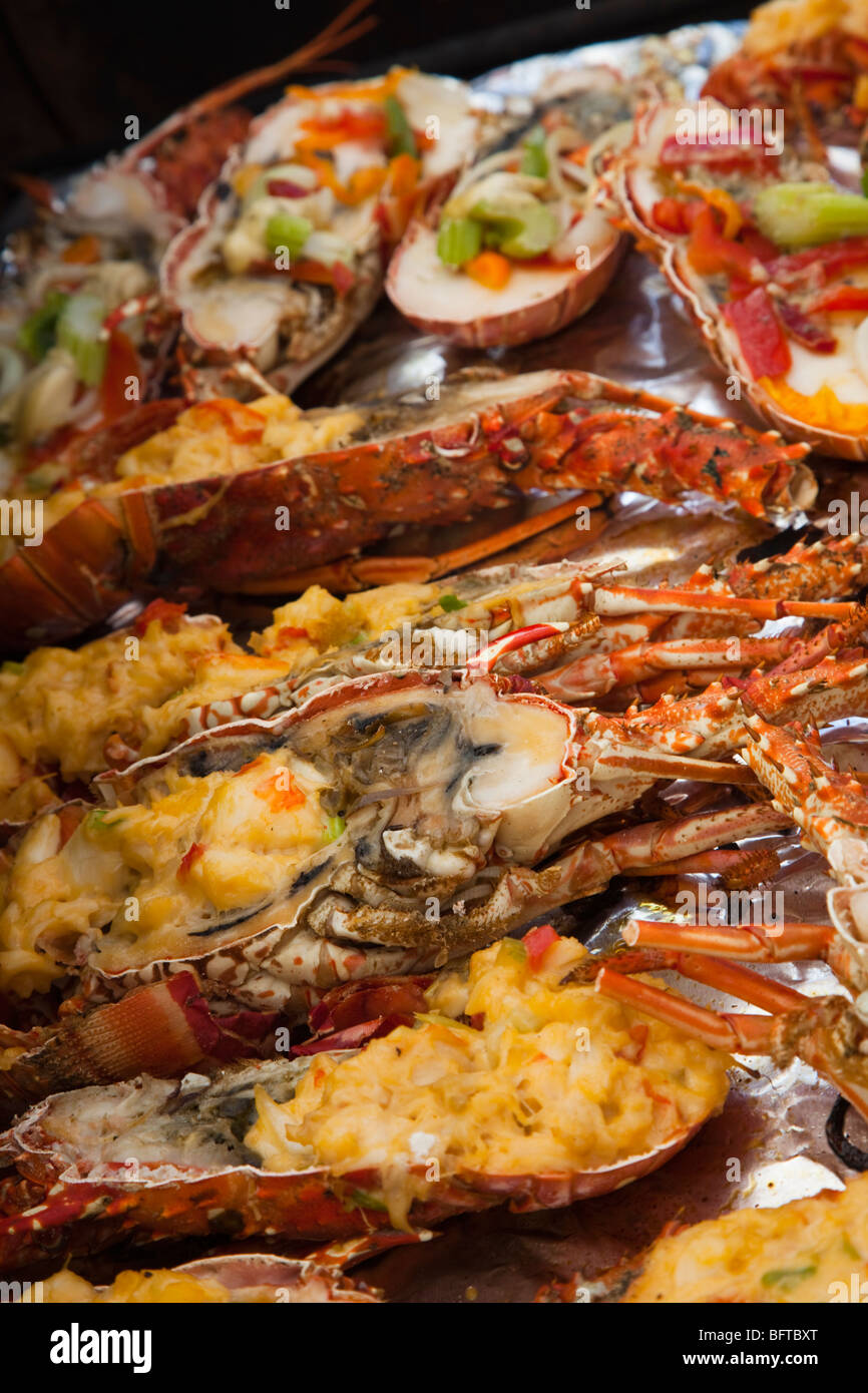 Cooked lobster prepared in its shells and with garnish, being barbecued ...