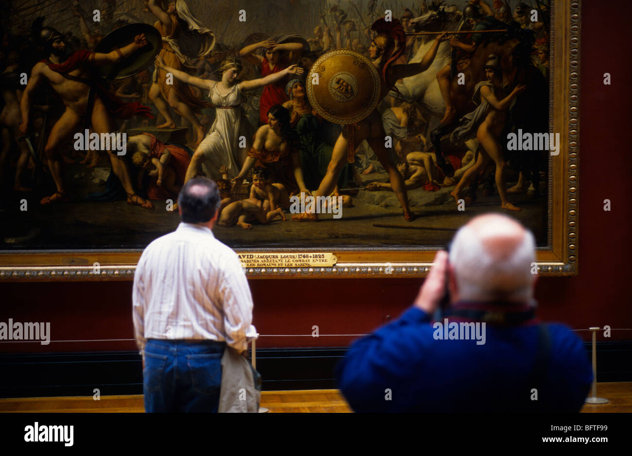 Tourists viewing the painting The Intervention of the Sabine Women by ...