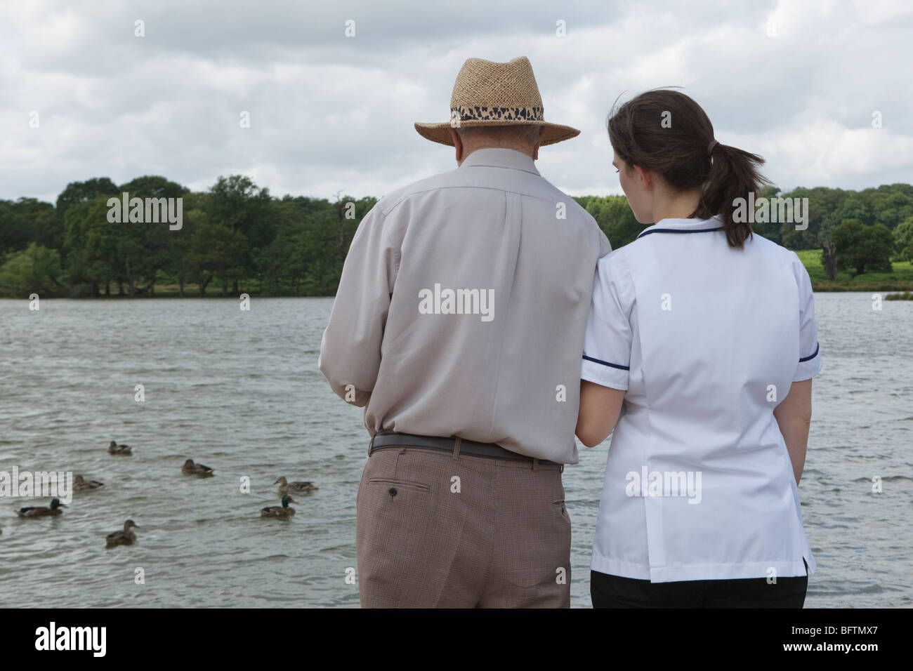 Nurse supporting elderly man Stock Photo - Alamy