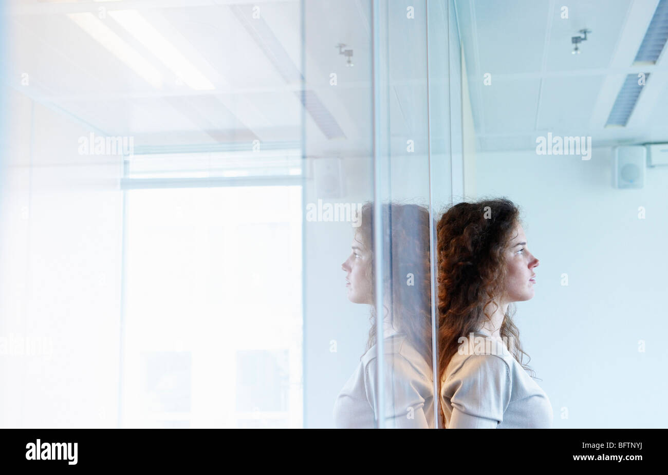 Woman against window, thinking Stock Photo - Alamy
