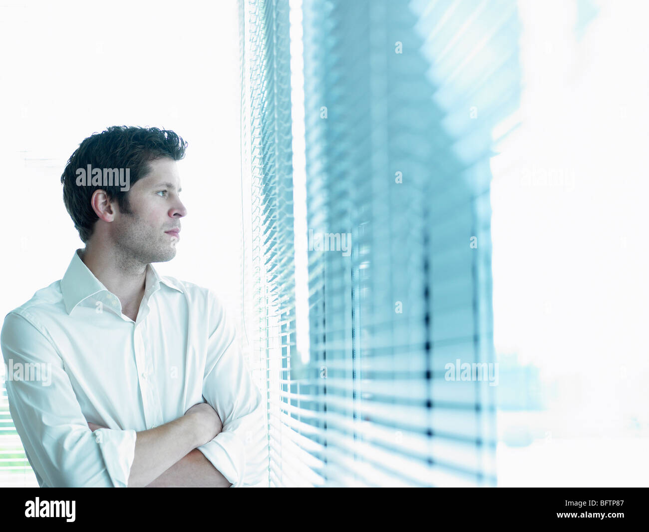 Business man looking through window Stock Photo - Alamy