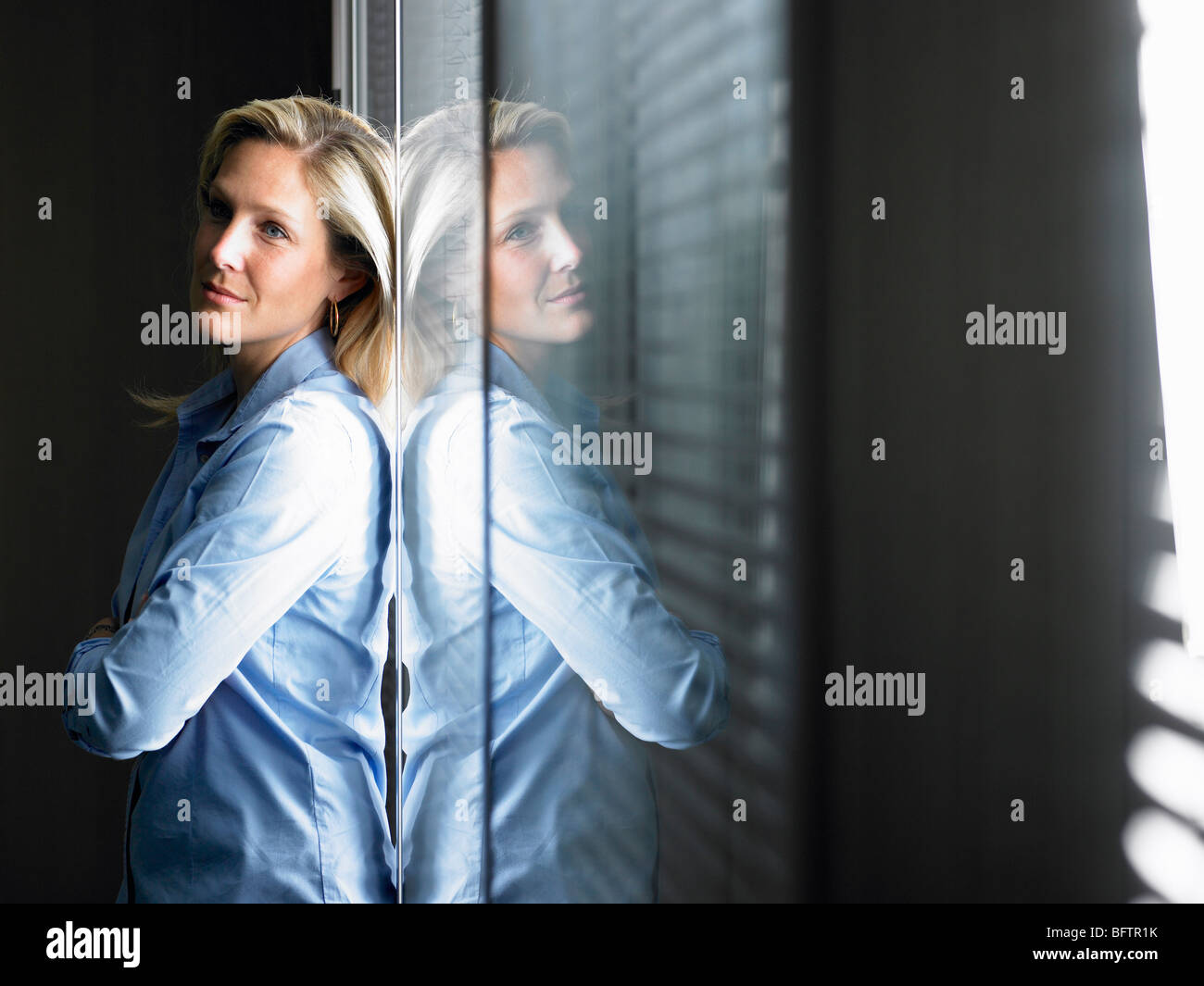 Woman against window, thinking Stock Photo - Alamy