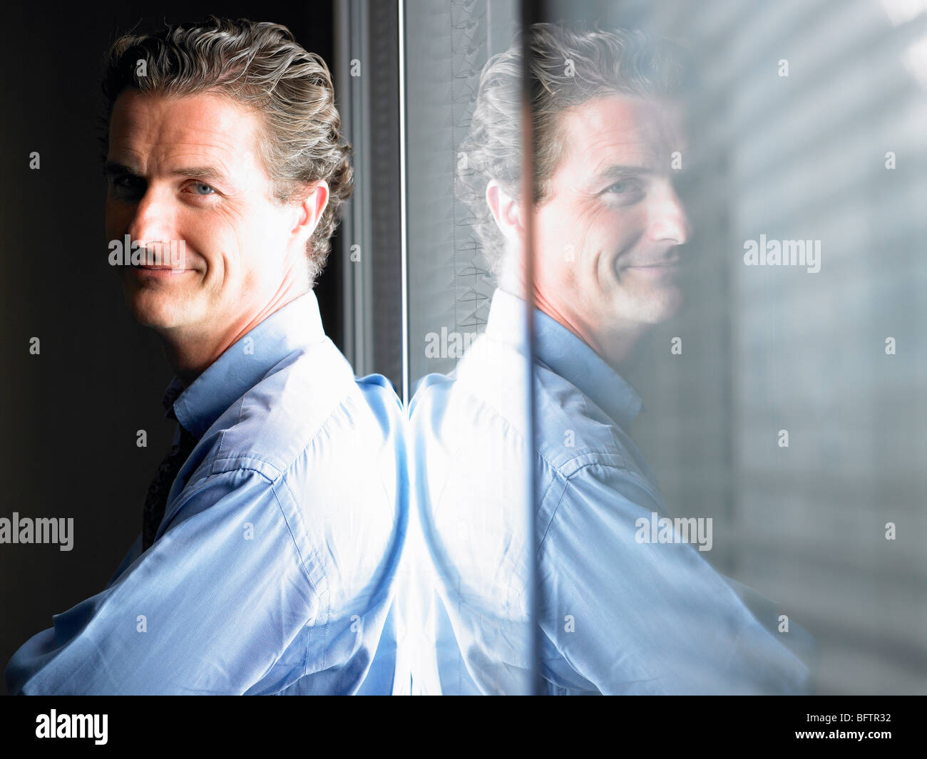 Man against window, smiling Stock Photo - Alamy