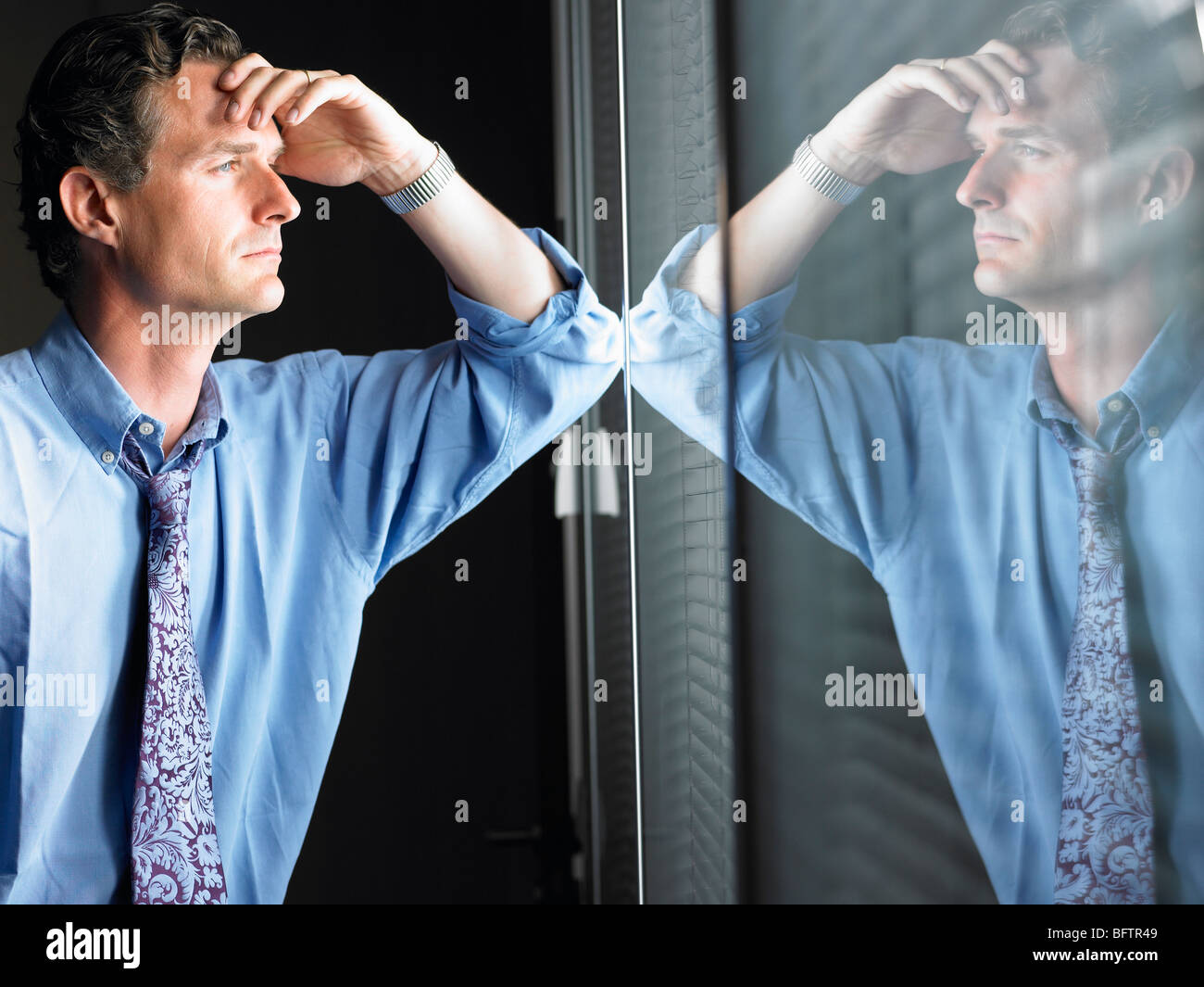 Man against window, thinking Stock Photo - Alamy