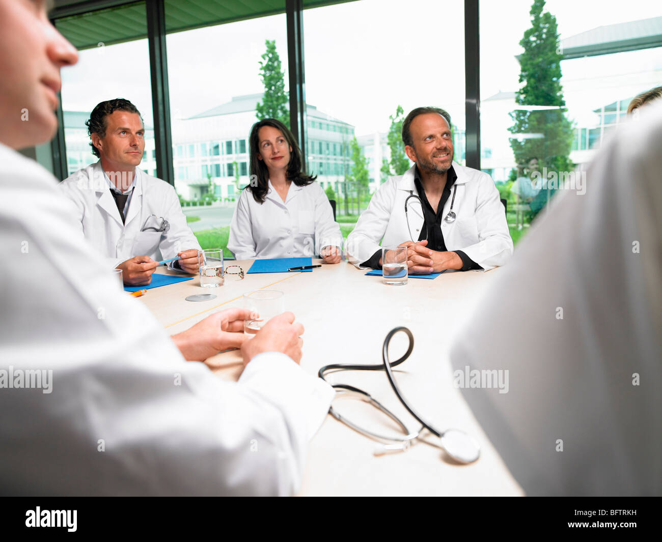 Doctors around a table Stock Photo - Alamy