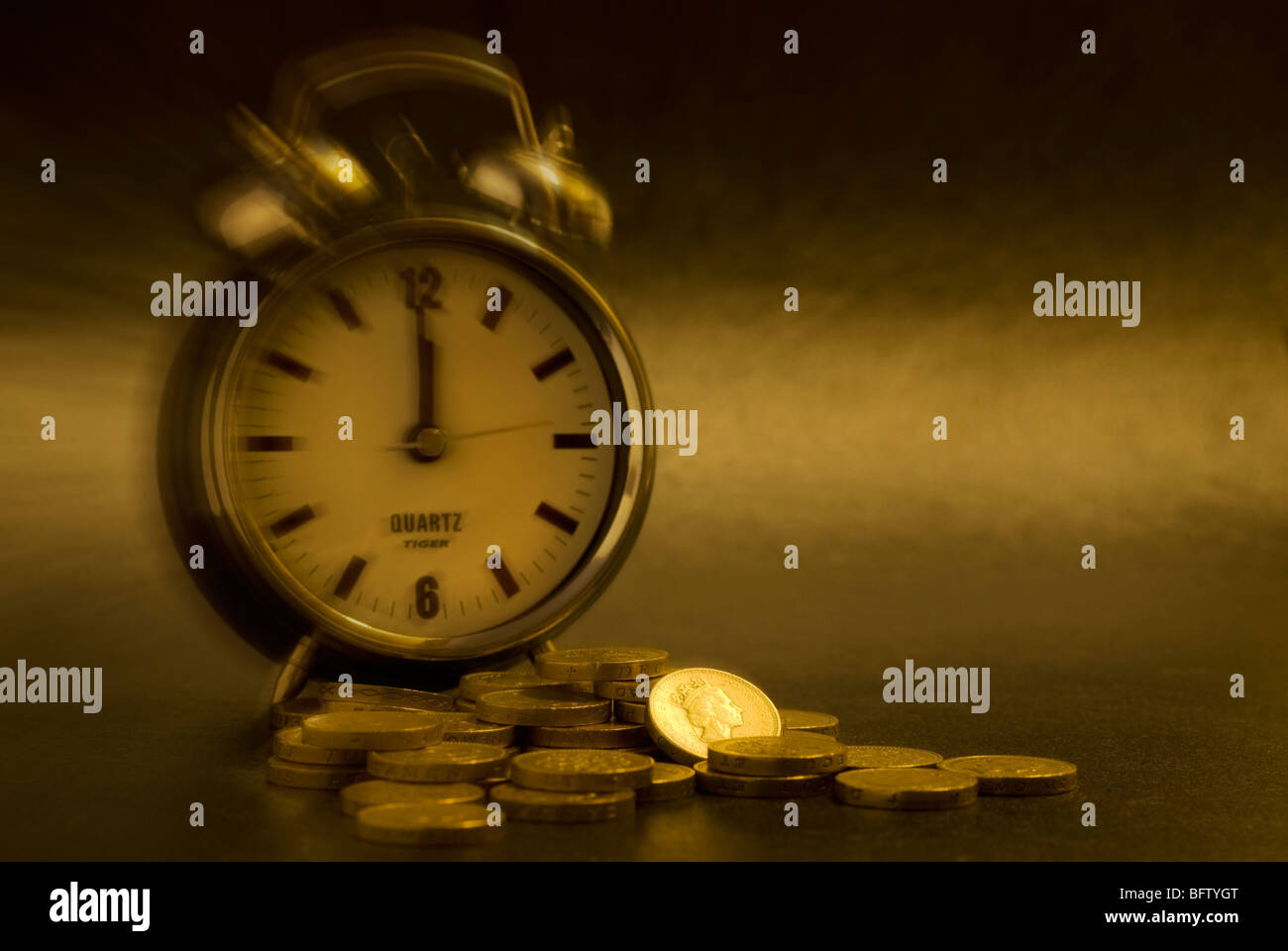 An alarm clock ringing next to a pile of one pound coins Stock Photo ...
