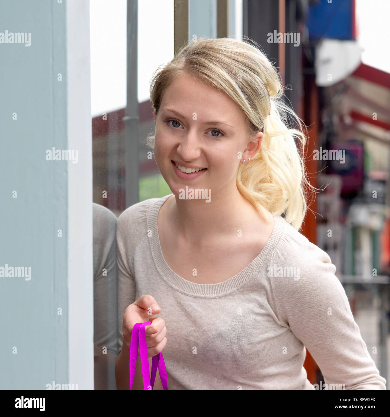 young woman next to a shop window Stock Photo - Alamy