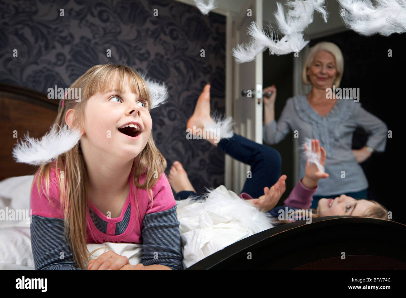Girl watches feathers after pillow fight Stock Photo - Alamy