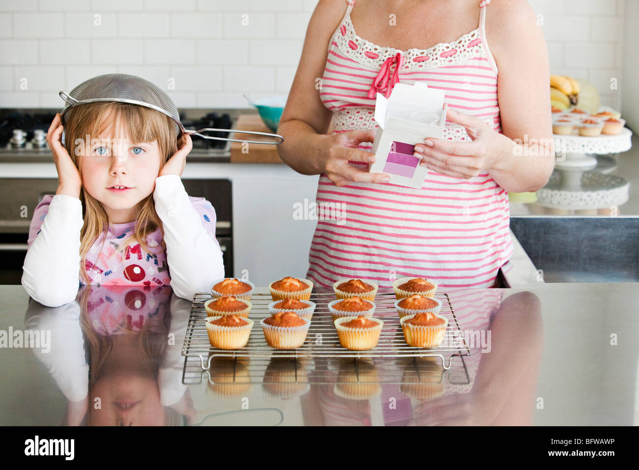 Girl baking with sieve on her head Stock Photo - Alamy