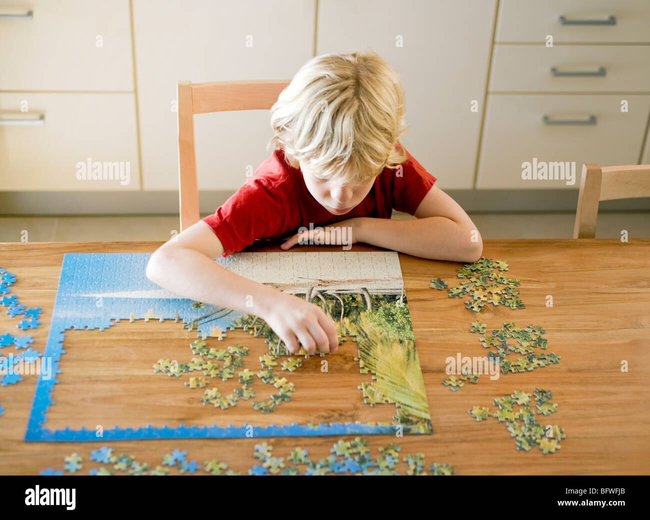 Portrait of a boy doing a puzzle Stock Photo - Alamy