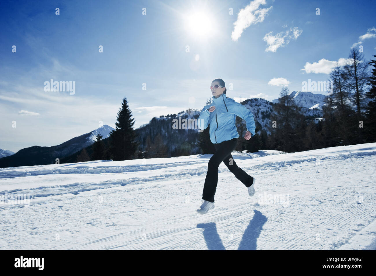 Young woman running in snow Stock Photo - Alamy