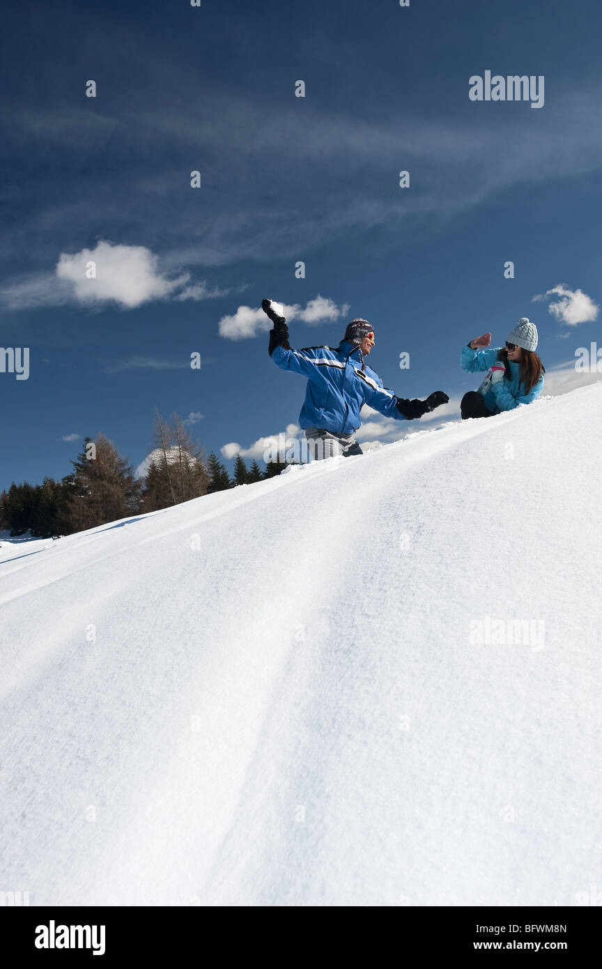 Couple in snow, young man throwing snowball Stock Photo - Alamy