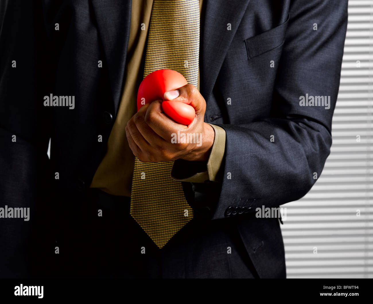 Business man squeezing stress ball Stock Photo - Alamy